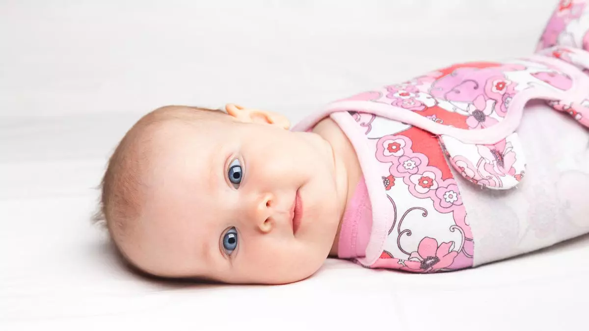 Младенец уютно запеленанный в розово-белую пеленку