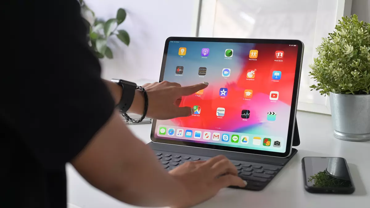 Umugore akoresha iPad Pro akoresheje clavier yemewe ya Apple.