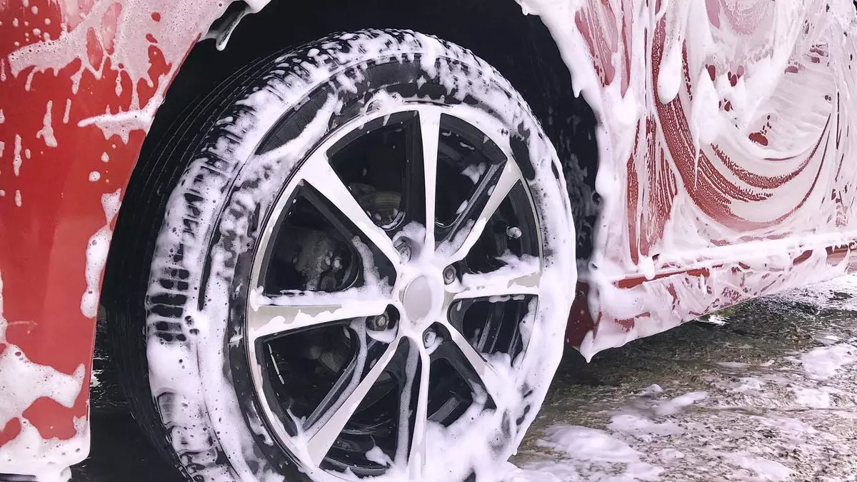 Roda e llanta do coche, espumosas durante o lavado do coche