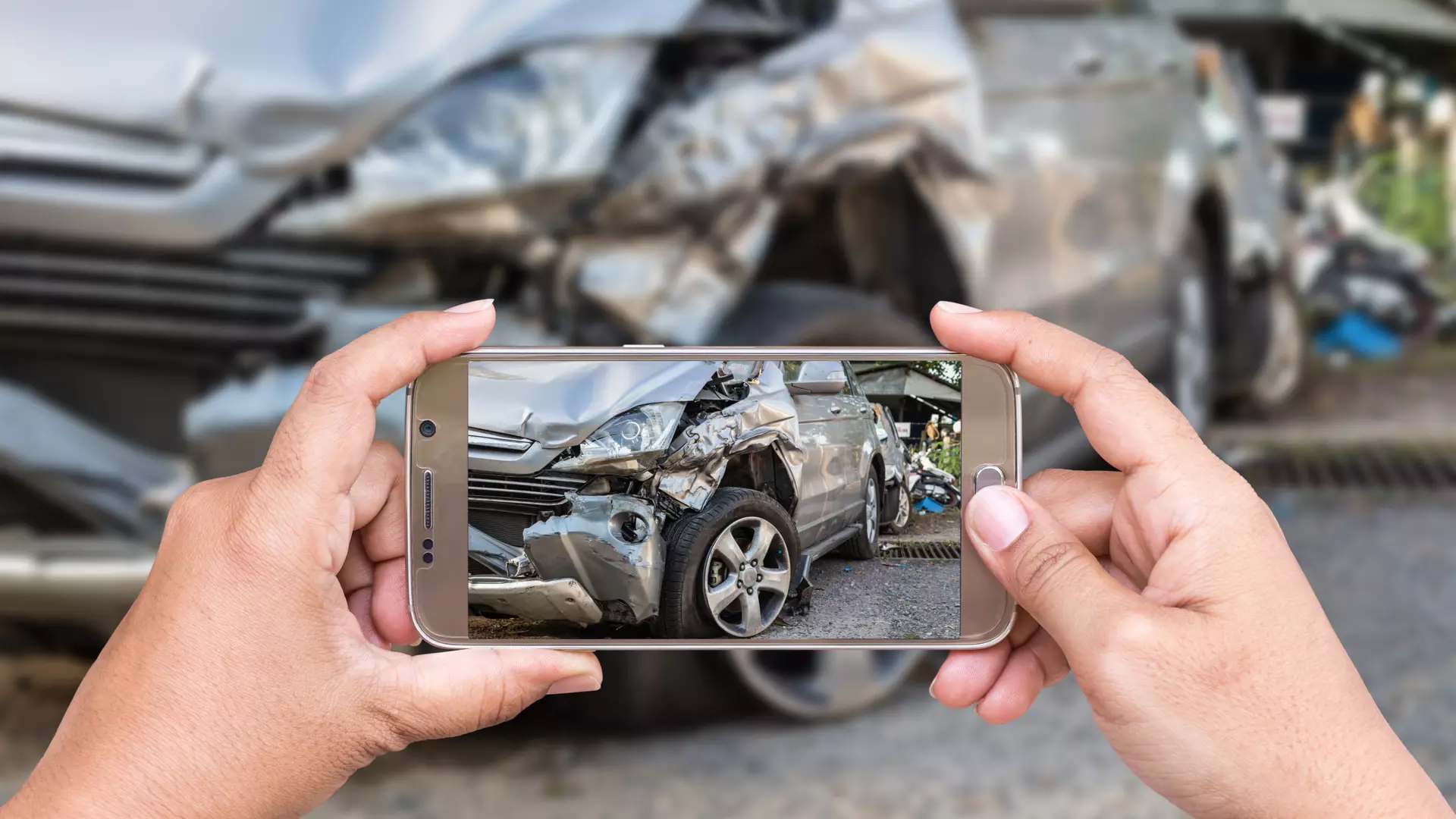 Затворете ја раката на жена која држи паметен телефон и фотографирајте сообраќајна несреќа