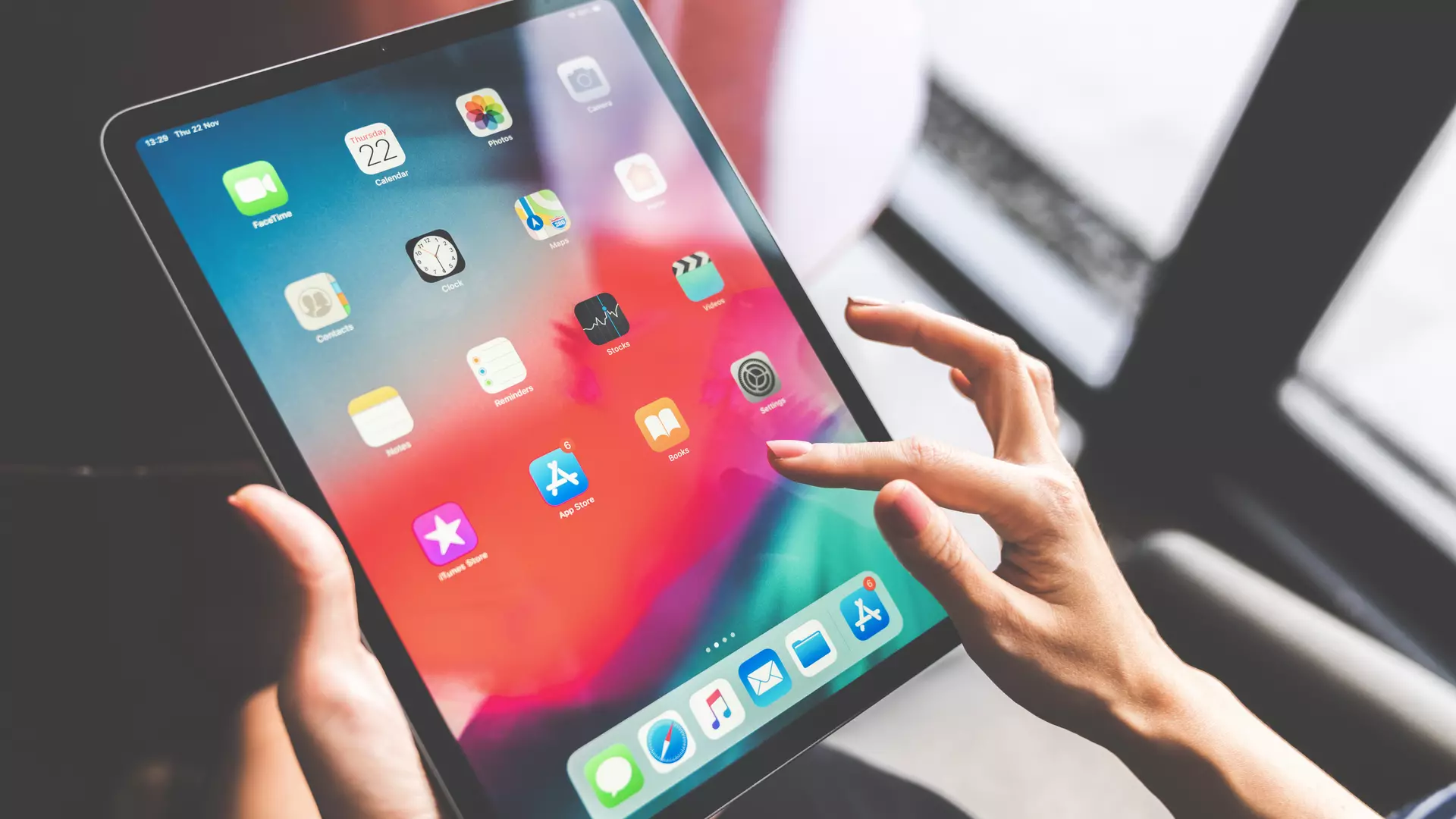Asmuo, naudojantis 2018 m. 11 colių Apple iPad Pro, perbraukiantis pagrindinį ekraną arba paliečiantis programos piktogramą. Iliustracinis redakcinis turinys